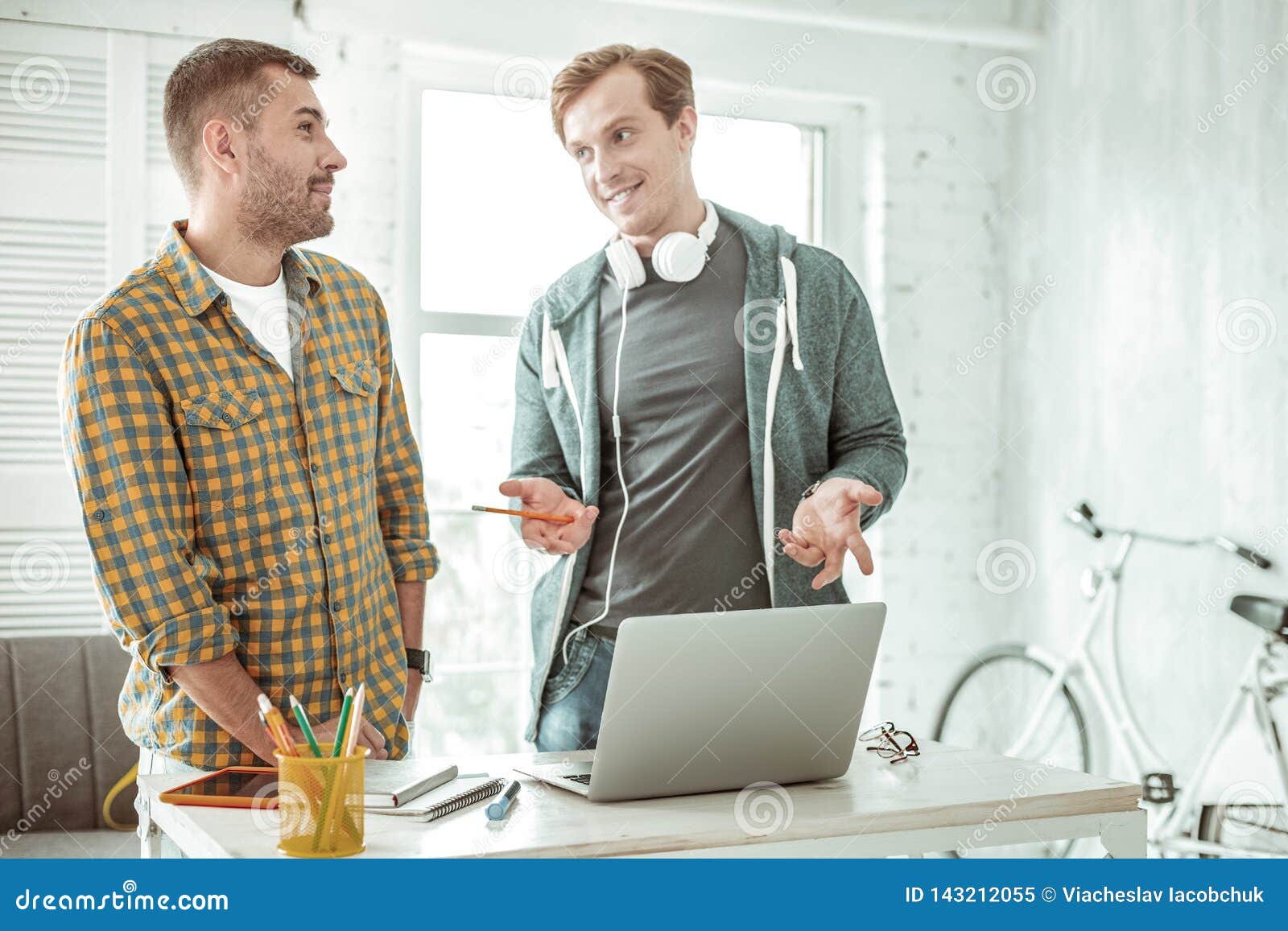 Positive Young Men Having a Conversation at Work Stock Image - Image of ...