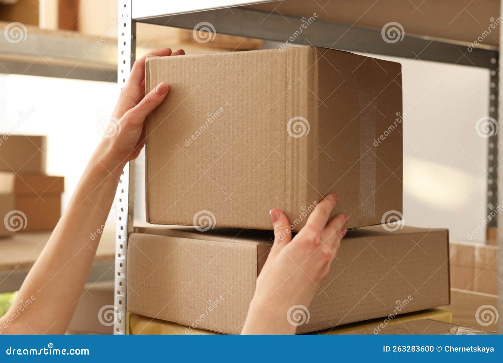 Post Office Worker Putting Box on Parcel Rack with Parcels Indoors ...