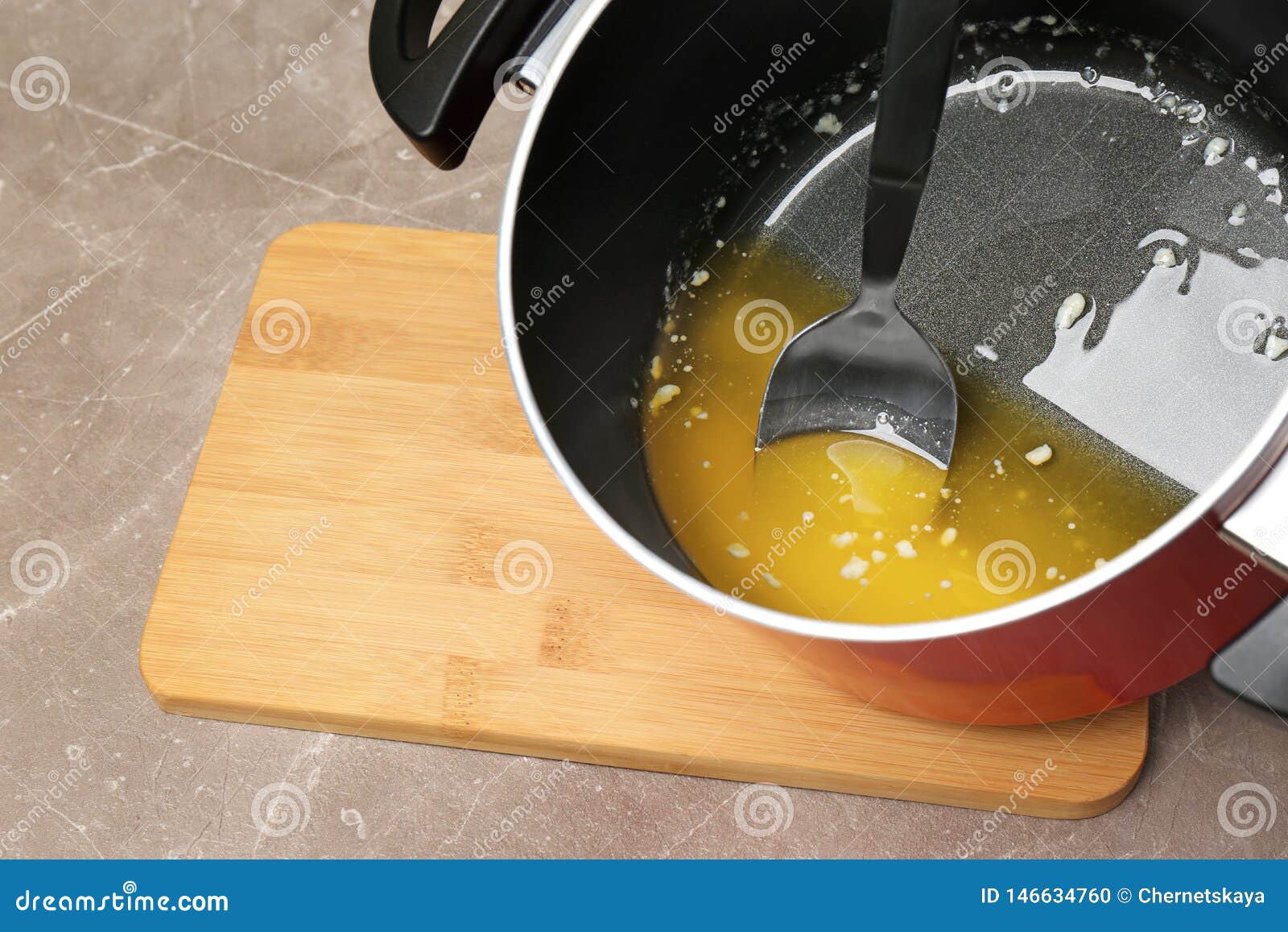 Pot with Melting Butter and Spoon on Grey Table, Closeup. Stock Photo ...