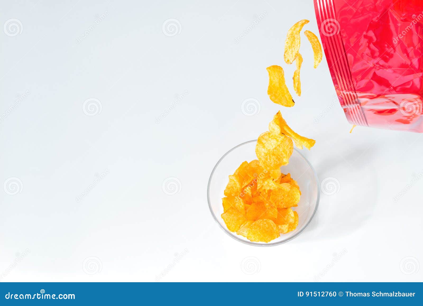Potato Chips Falling Out of a Packet of Crisps into a Glass Bowl on ...
