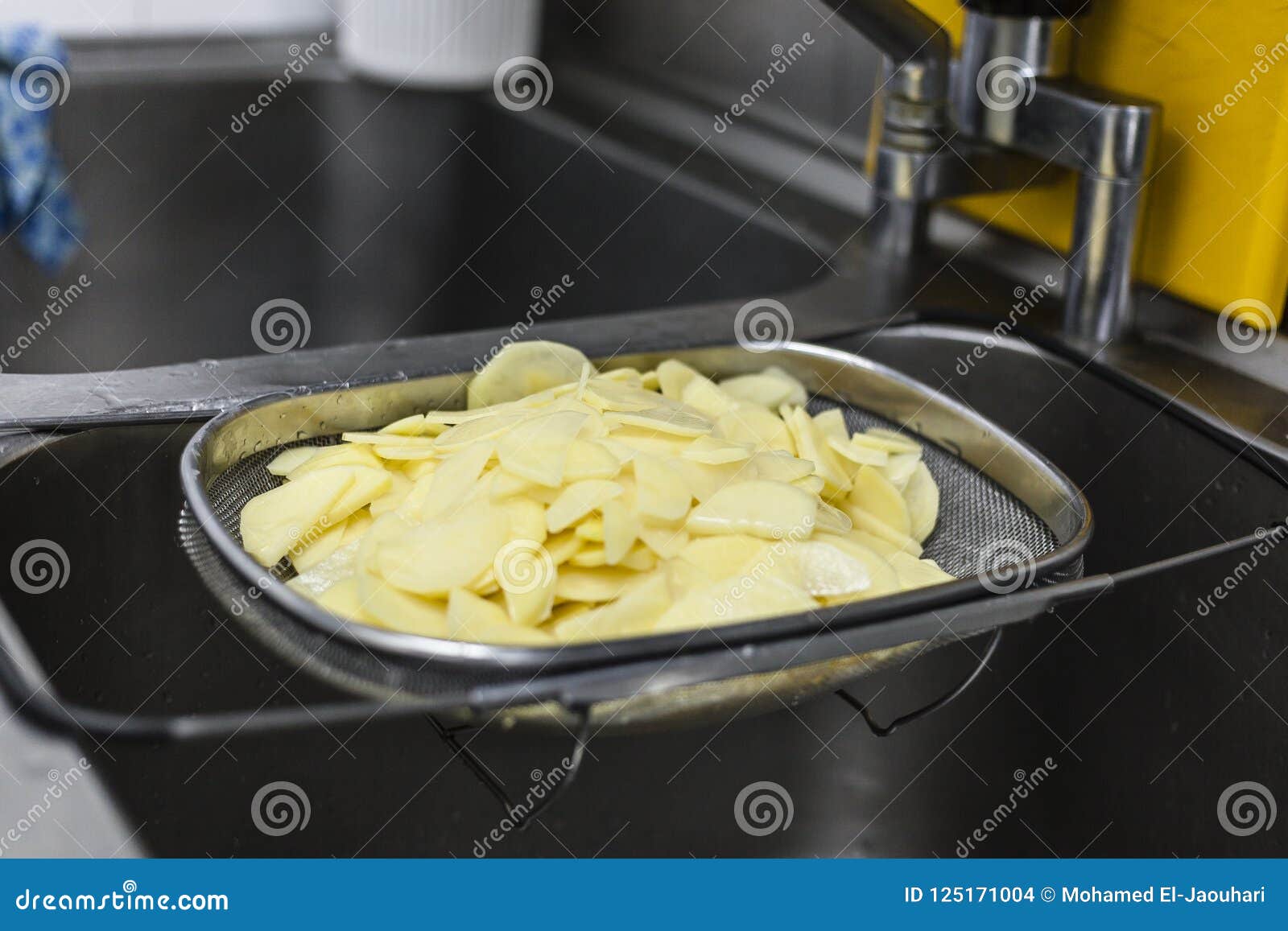 Potato Slices Draining in a Strain on an Industrial Kitchen Sink. Stock ...
