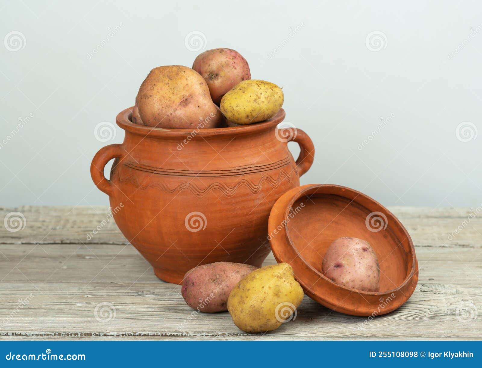 Potatoes in Rustic Clay Dishes on a Table Made of White Boards Stock ...