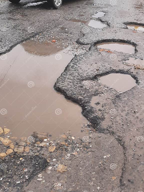 Potholes in the road stock image. Image of road, sludge - 355298701