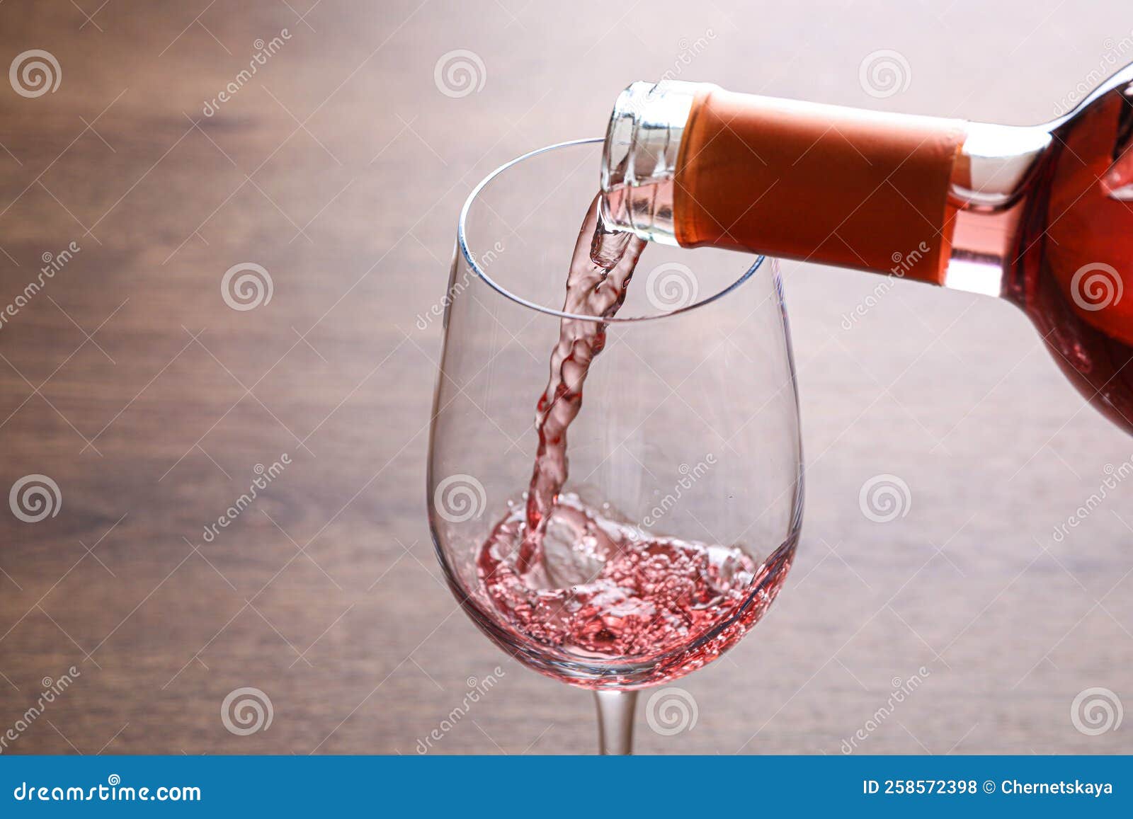 Pouring Delicious Rose Wine into Glass on Wooden Table, Closeup Stock ... Pouring Delicious Rose Wine into Glass on Wooden Table, Closeup Stock ...