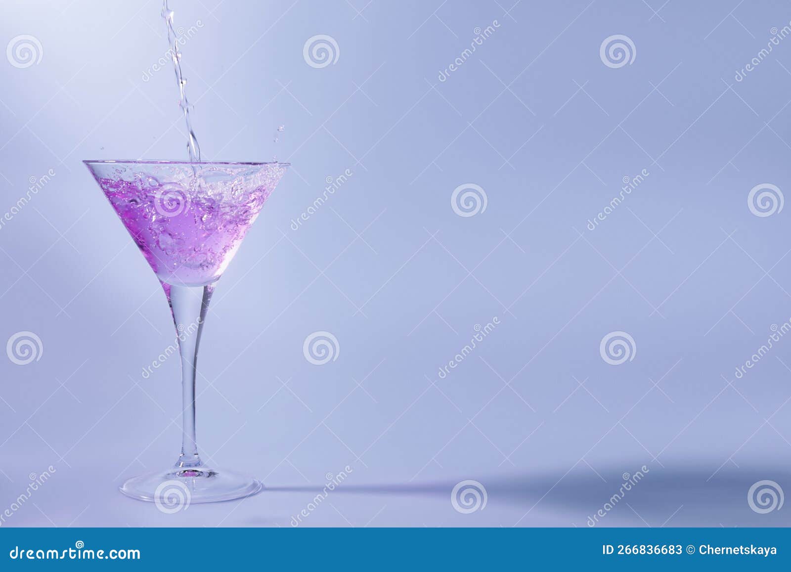 Pouring Fresh Cocktail into Martini Glass on Light Blue Background ...
