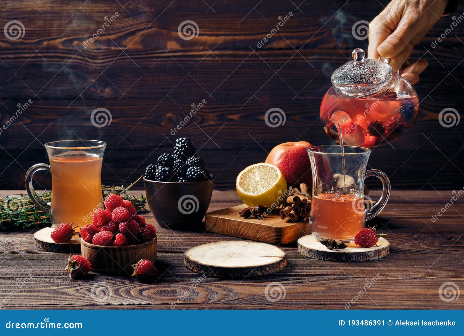 Pouring Fruit Tea with Raspberries, Bramble, Apple and Lemon in Cup ...