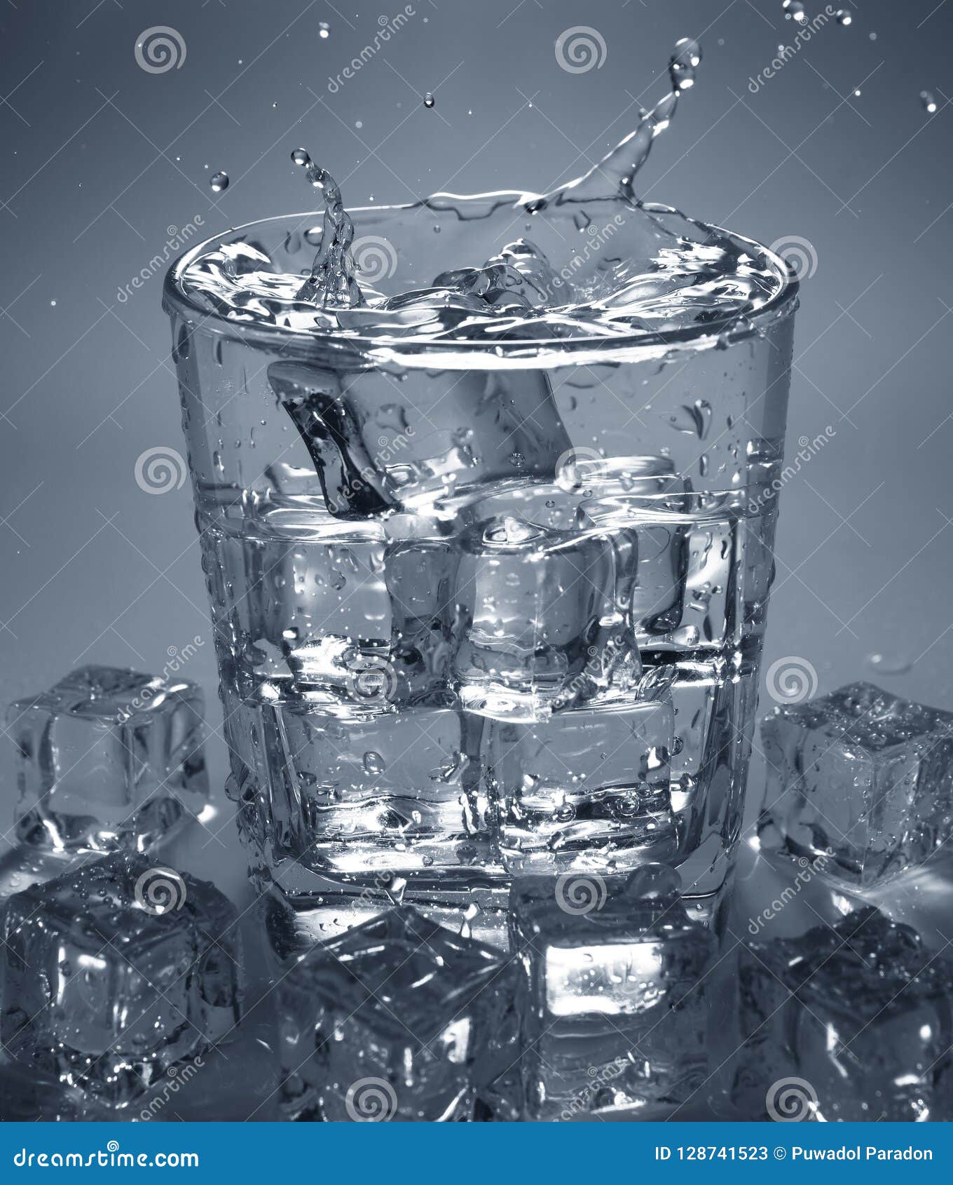 Pouring Ice Cube into Drink Glass of Water. Splashing Water. Stock ...