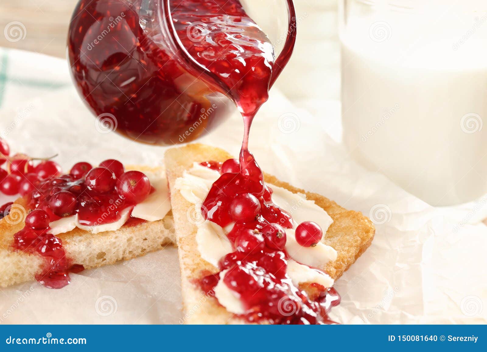 Pouring Jam from Jug Onto Toast with Red Currant on Table Stock Photo ...