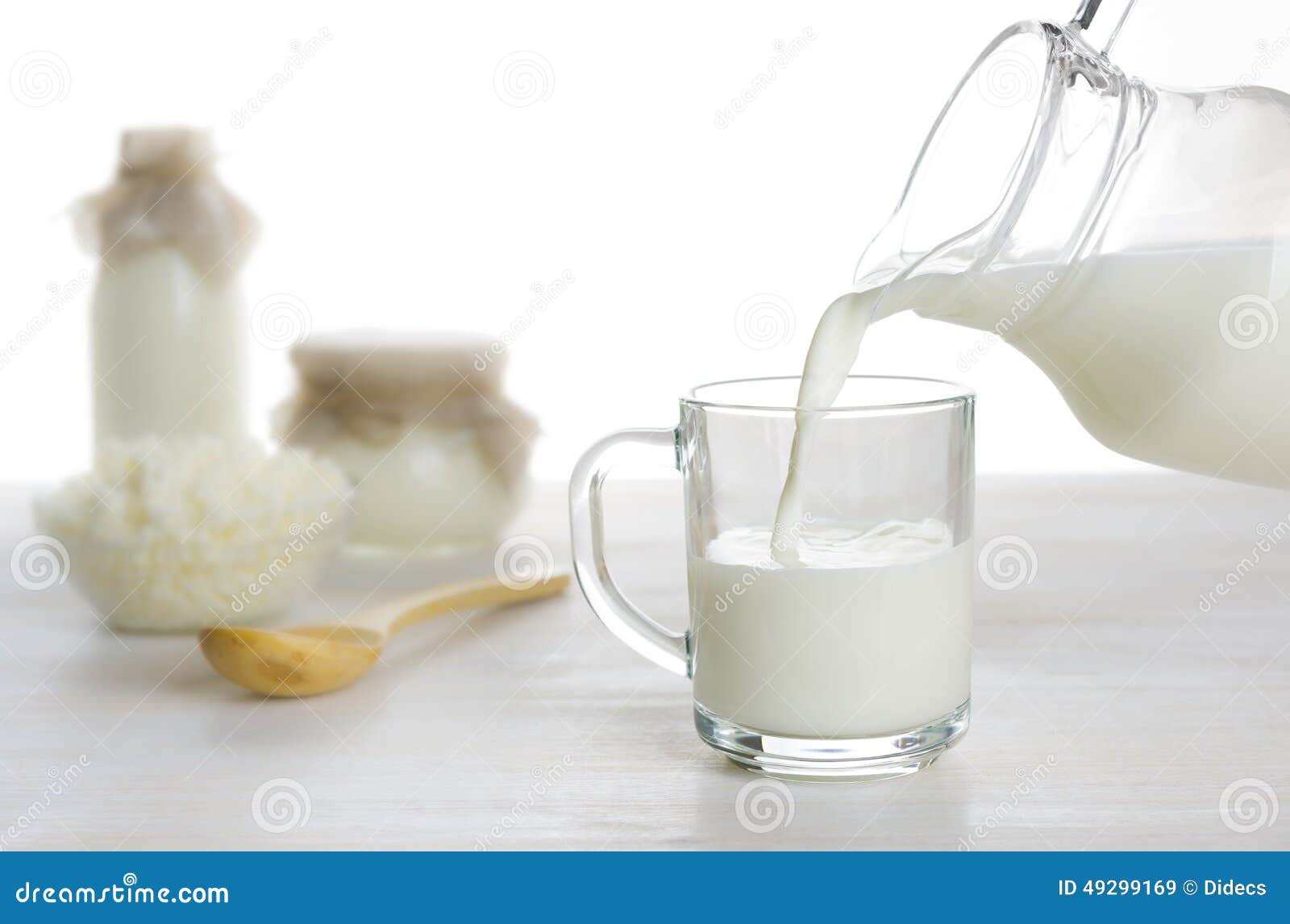 Pouring Milk In A Glass Of Iced Coffee Cubes On Dark Background ...