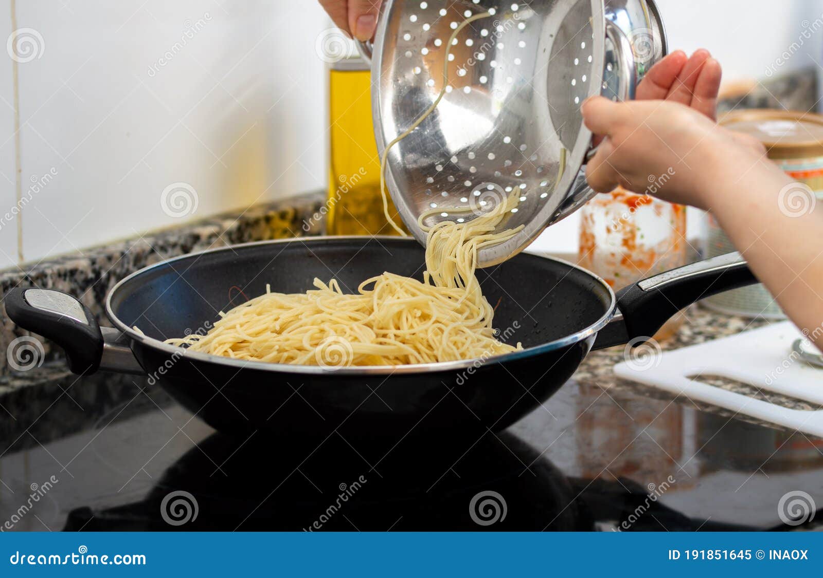 Pouring Spaghetti from a Silver Colander into the Wok Stock Image ...