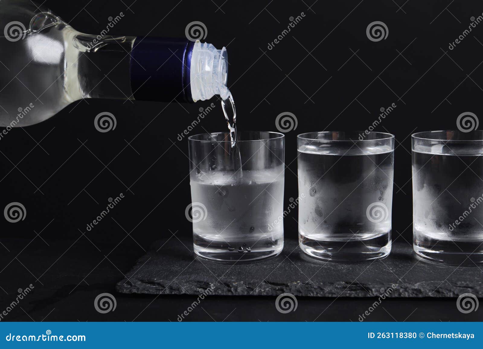 Pouring Vodka from Bottle in Glass on Black Table Stock Photo - Image ...