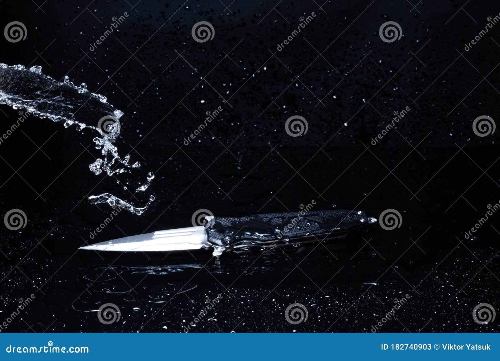 Pouring Water Onto a Spear-shaped Knife. Splashes of Water Around the ...