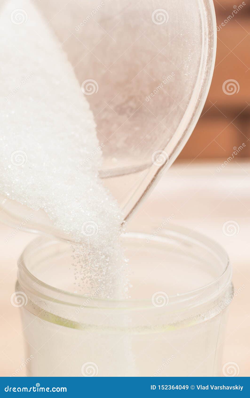 Pouring White Sugar into a Smaller Container for Ease of Use Stock ... Pouring White Sugar into a Smaller Container for Ease of Use Stock ...