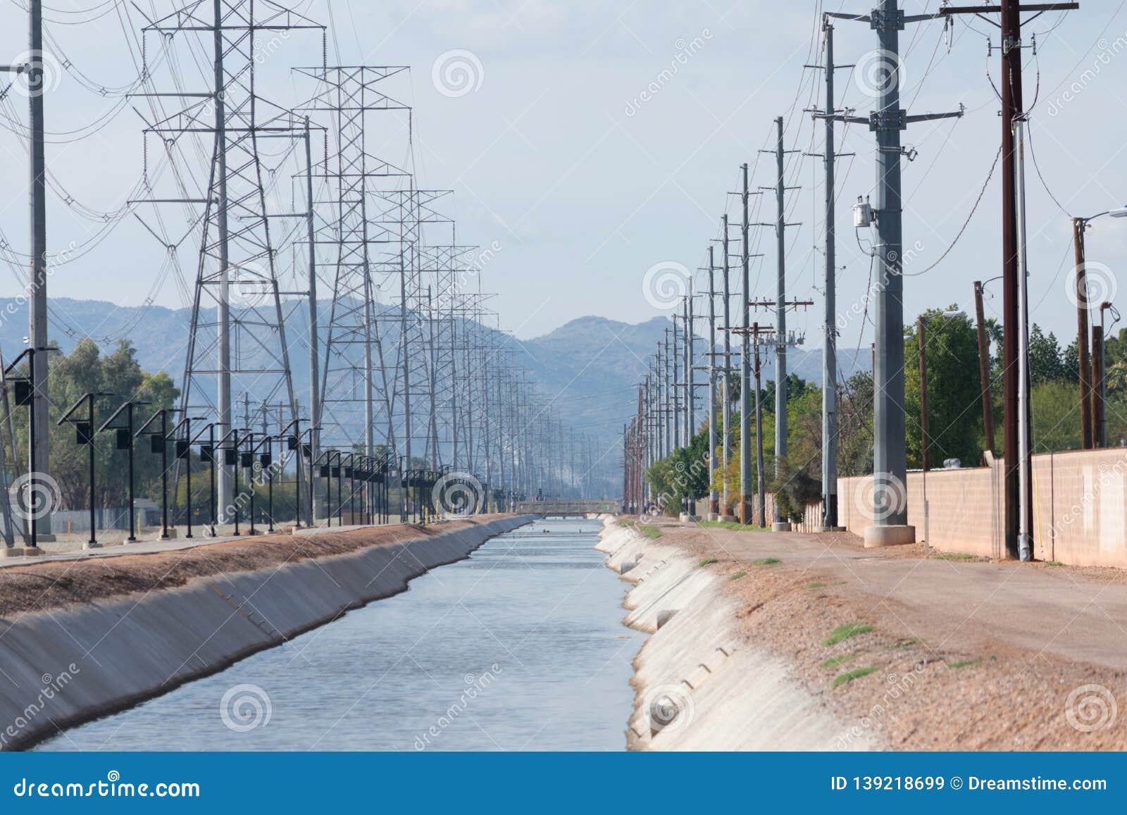 Power Lines on Both Sides of a Canal and Mountains in the Background ...