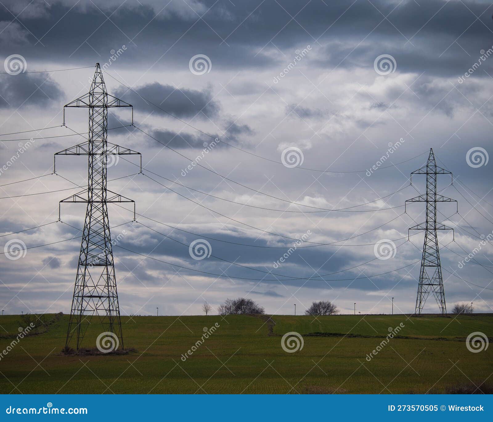 Power Lines Crossing a Grassy Landscape, with White Clouds in the ...