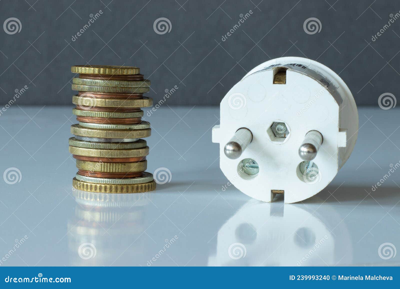 Power Plug and a Stack of Coins Isolated on White Surface with Grey ...