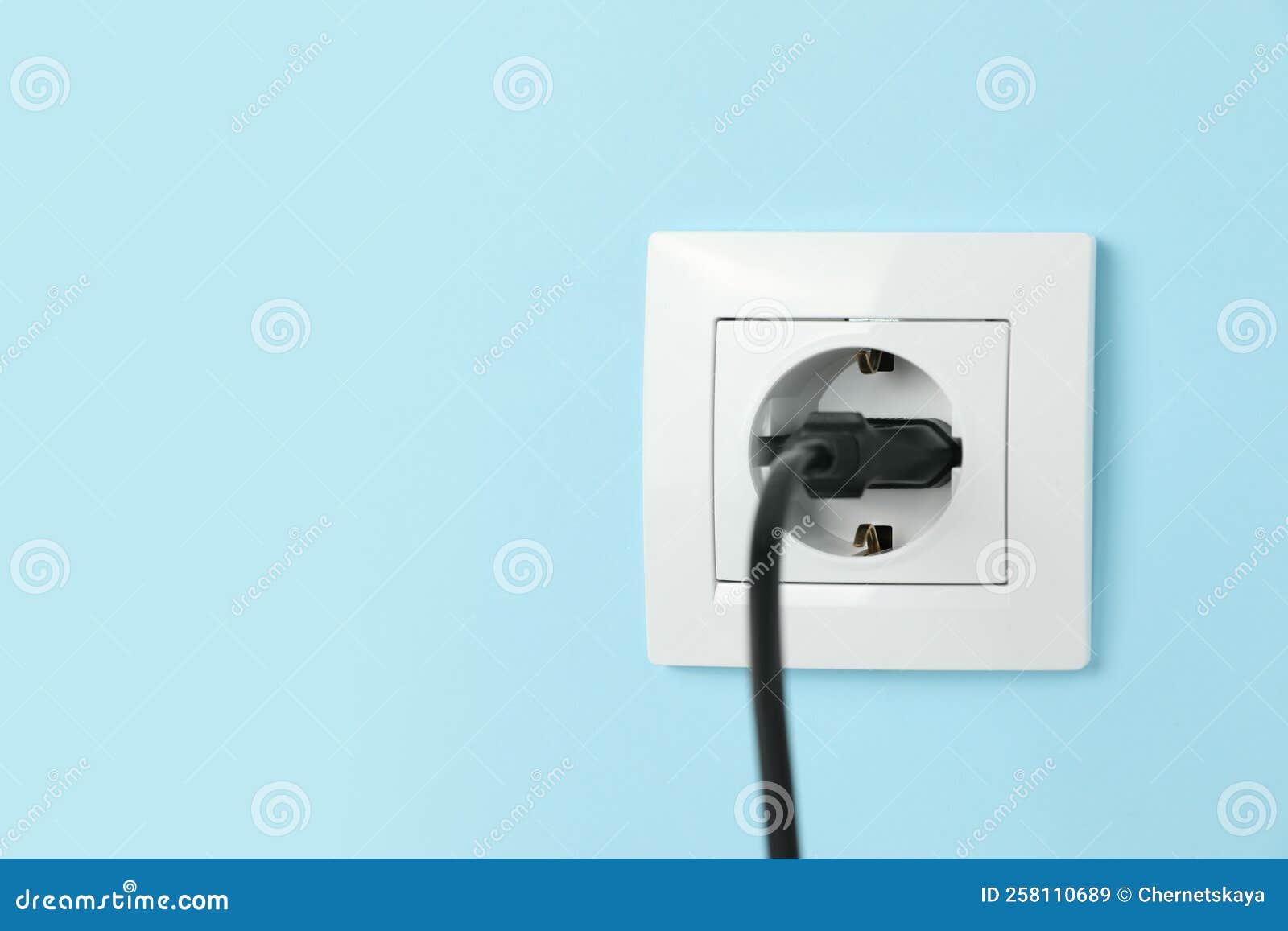 Power Socket with Inserted Plug on Light Blue Wall, Space for Text ...