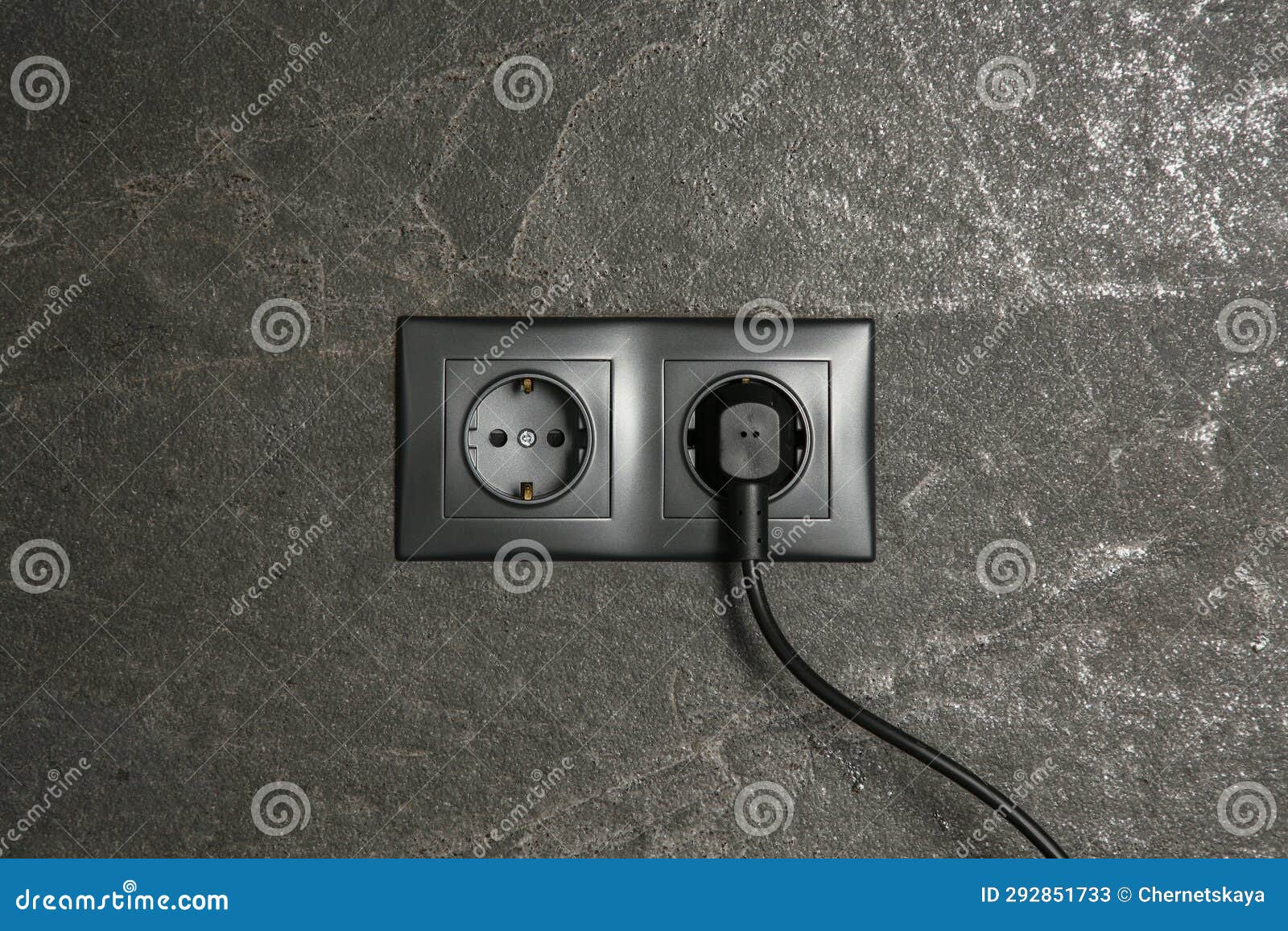 Power Sockets with Inserted Plug on Dark Grey Wall. Electrical Supply ...