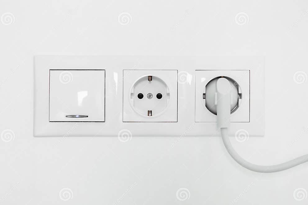 Power Sockets with Inserted Plug and Light Switch on White Wall Indoors ...