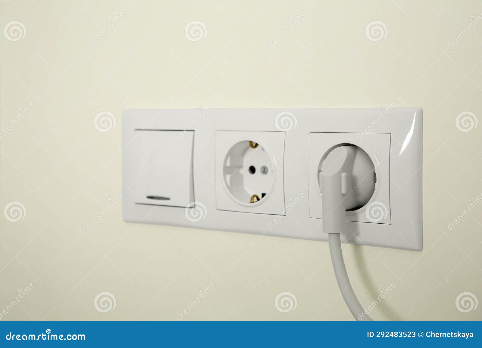 Power Sockets with Inserted Plug and Light Switch on White Wall Indoors ...