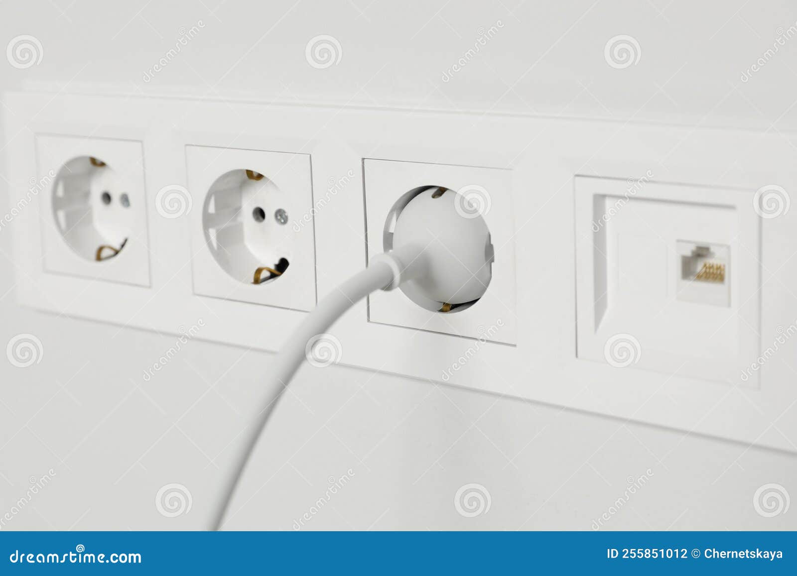 Power Sockets with Inserted Plug on White Wall, Closeup. Electrical ...