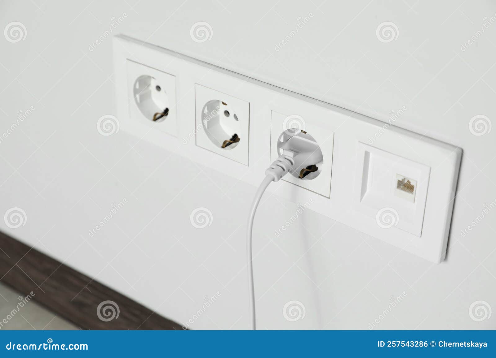 Power Sockets with Inserted Plug on White Wall Indoors, Closeup ...