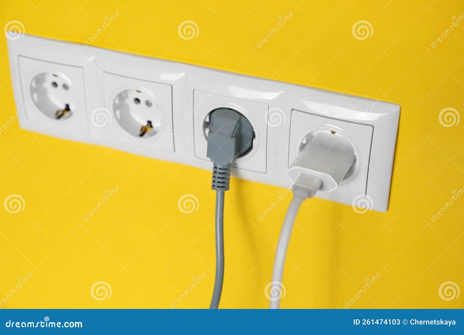 Power Sockets with Inserted Plugs on Yellow Wall, Closeup. Electrical ...