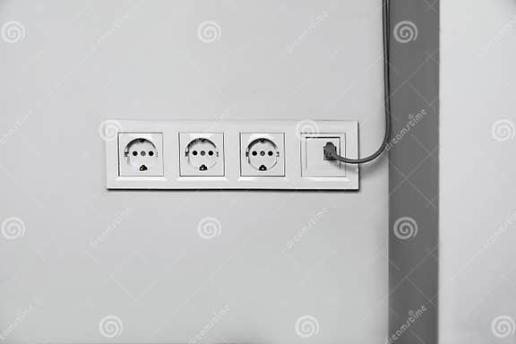 Power Sockets with Internet Cable on White Wall. Electrical Supply ...