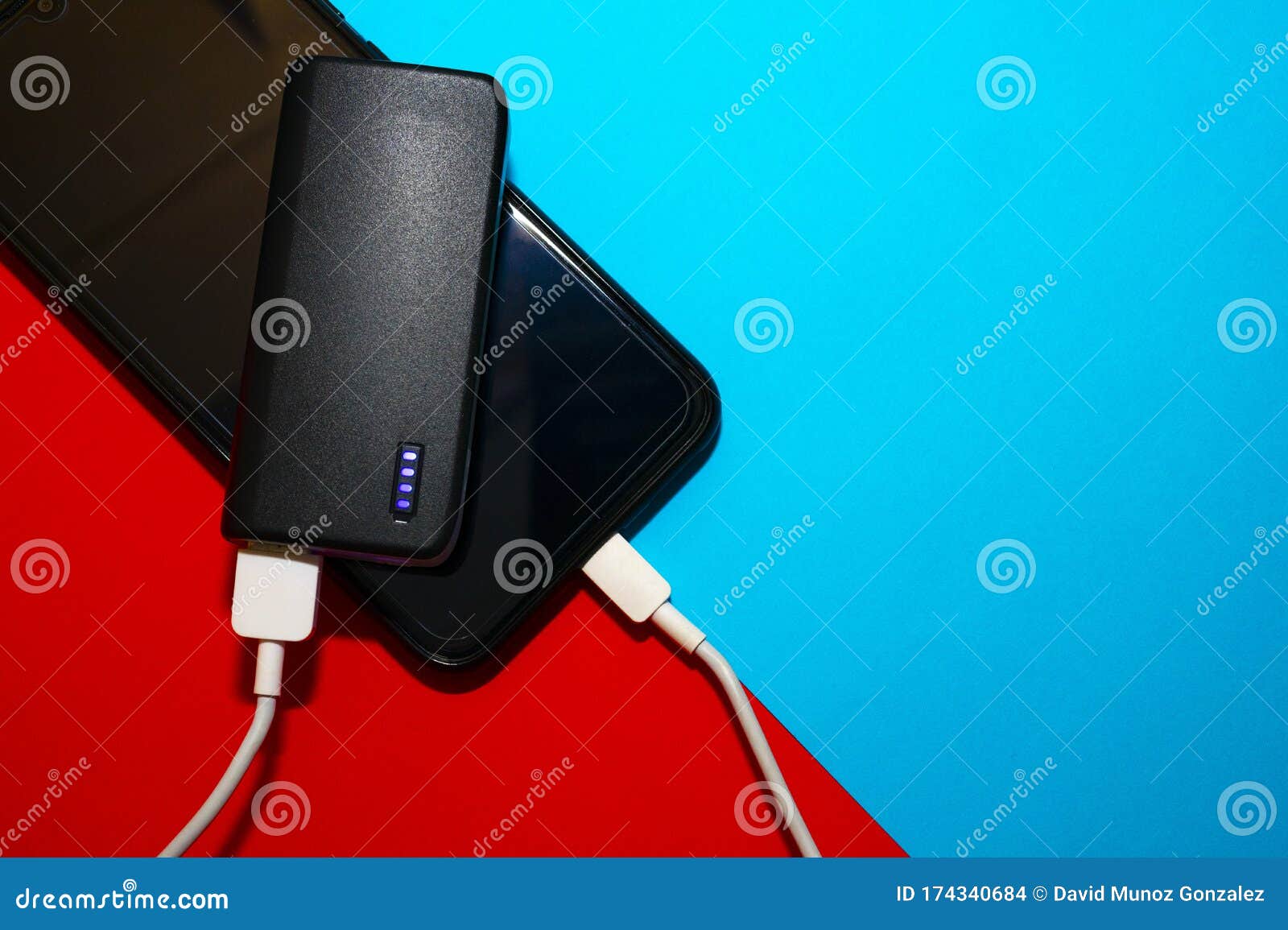 Powerbank Loading a Cell Phone on a Blue and Red Background Stock Photo ...
