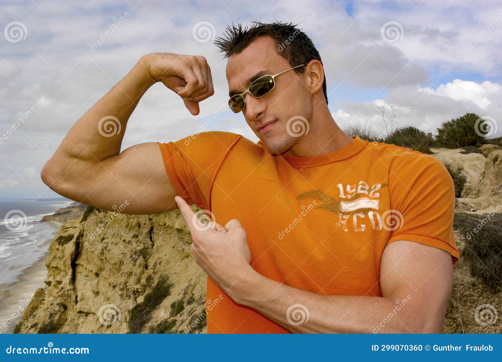 A Young Man Who is Athletically Fit and Appealing Flexes His Biceps ...