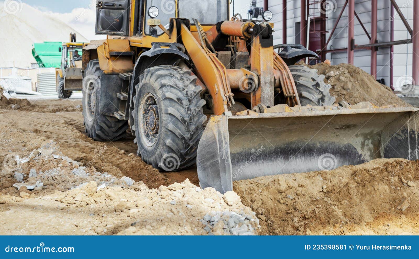 A Powerful Front Loader on the Construction Site Performs Sanding ...
