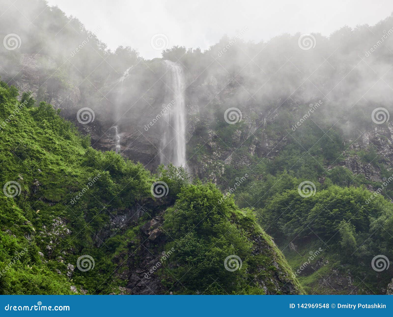 A Powerful Mountain Stream Flows Down from the Rocks in a Dense Fog ...