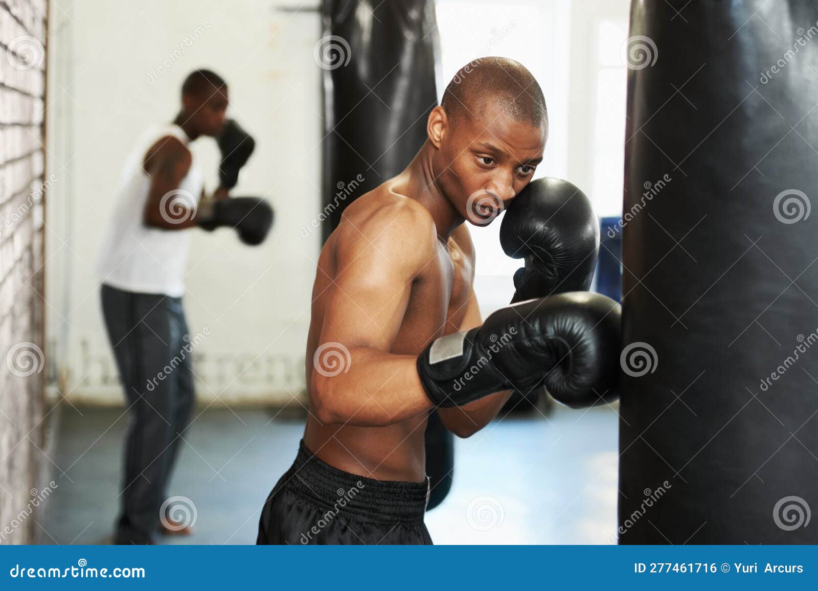 Practice Will Take Him Far. a Young Boxer Smacking a Punching Bag at ...