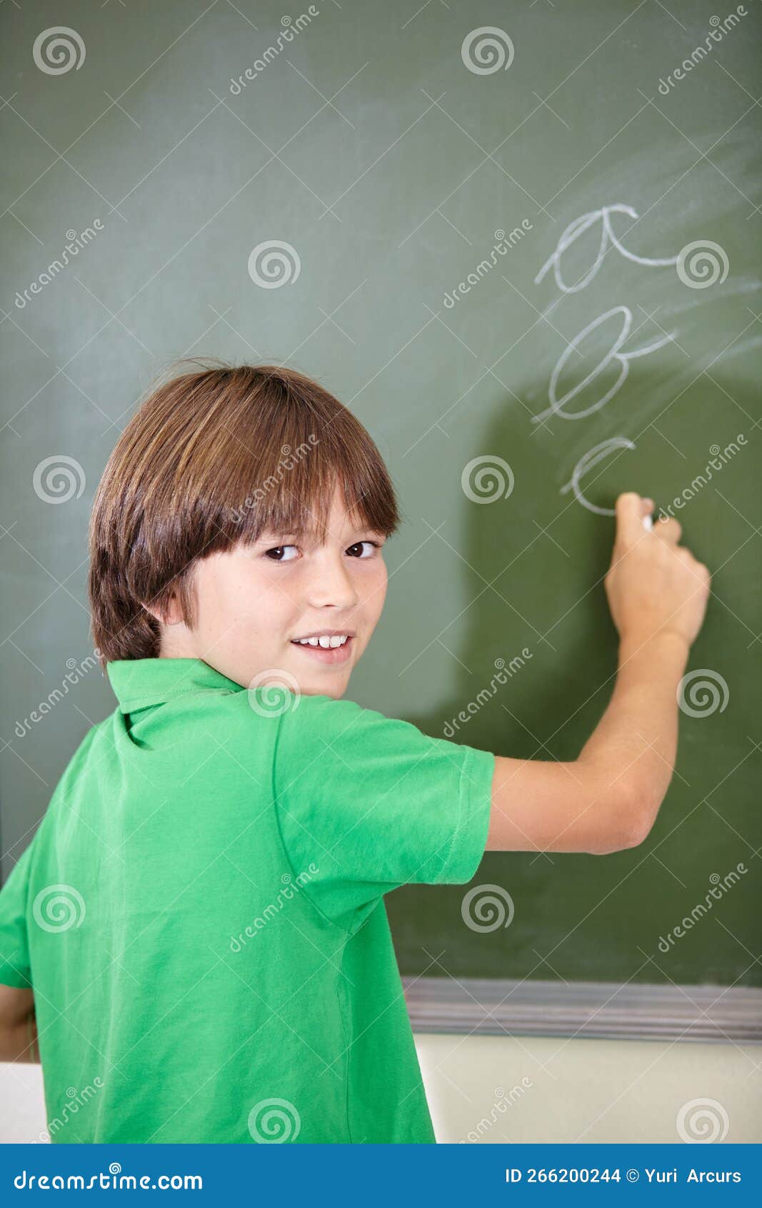 Practicing His Cursive Writing. a Little Boy Writing on the Blackboard ...