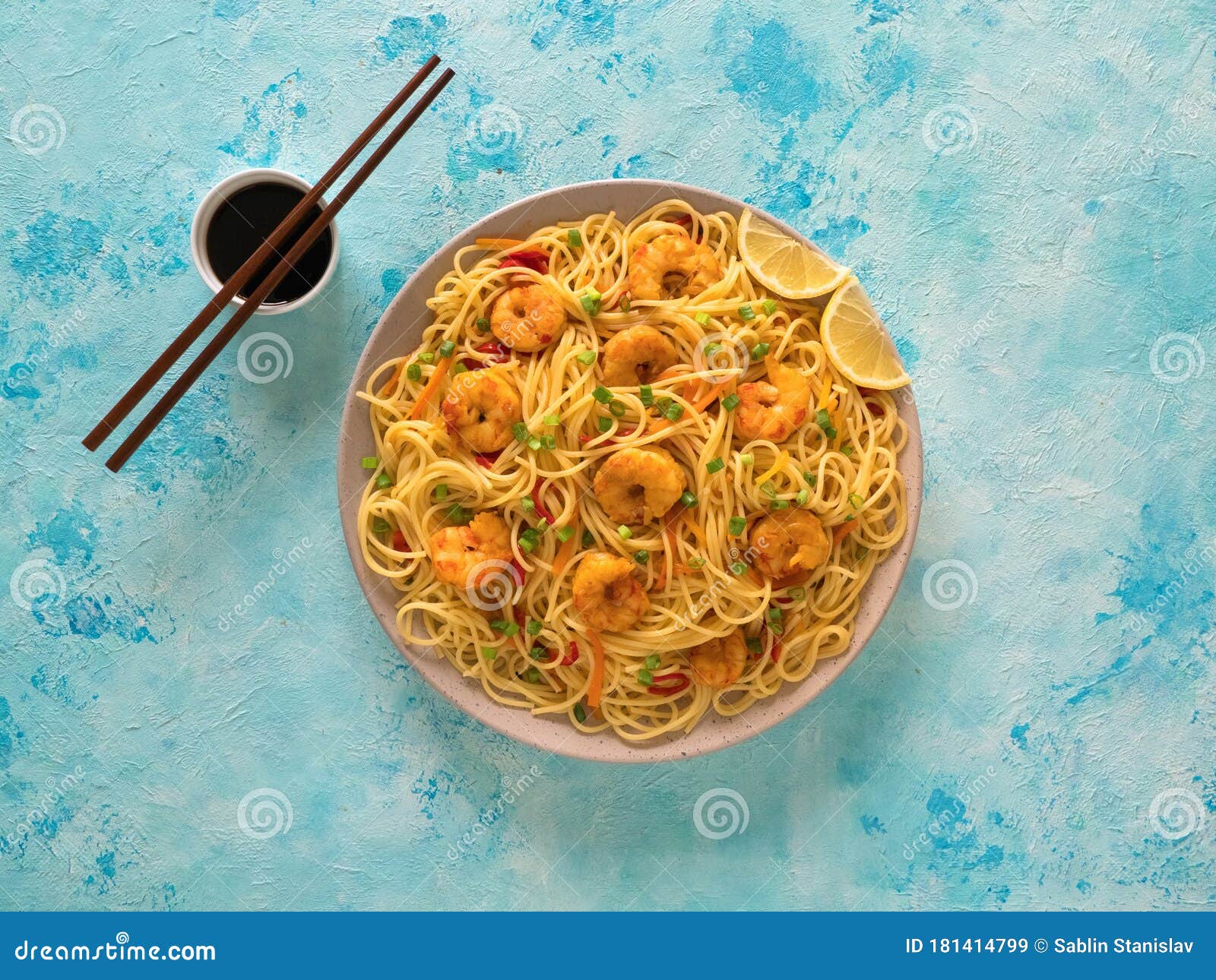 Prawn Schezwan Noodles With Vegetables In A Plate On A Blue Table Top
