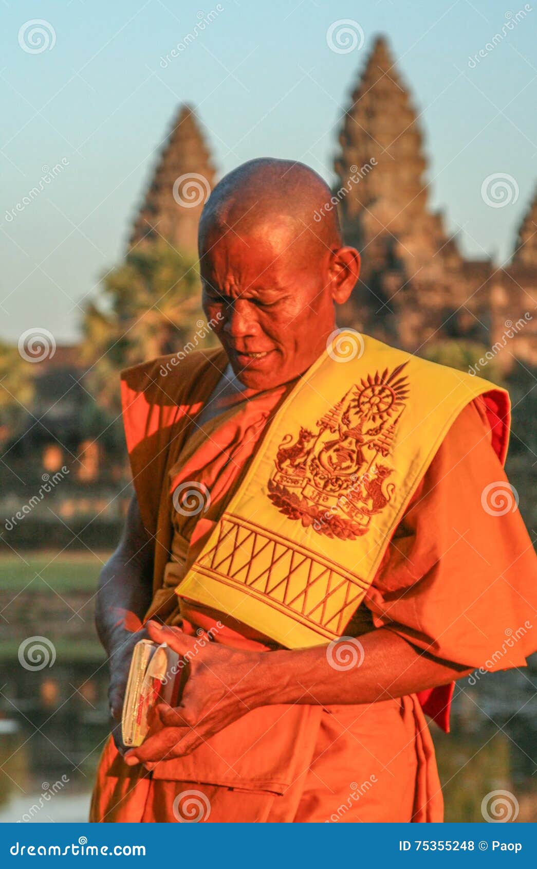 Praying monk at Angkor Wat editorial stock photo. Image of book - 75355248