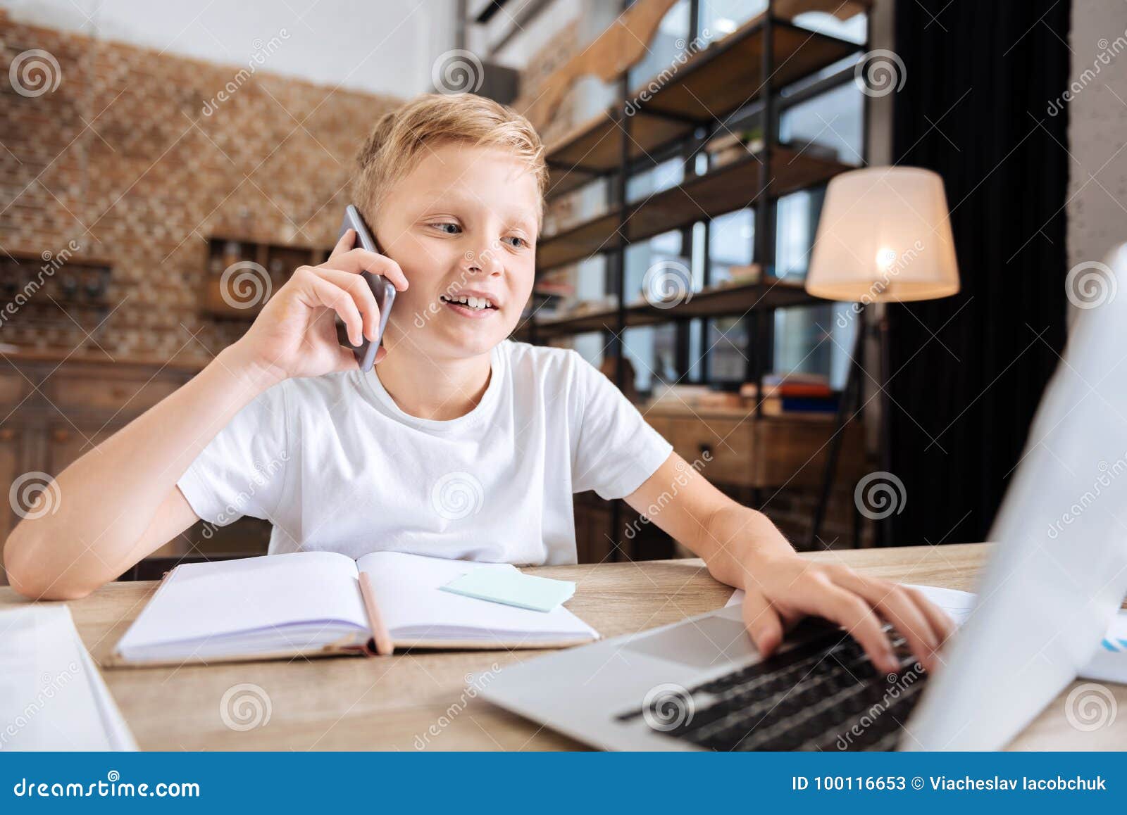 Pre-teen Boy Talking on the Phone while Using Laptop Stock Image ...