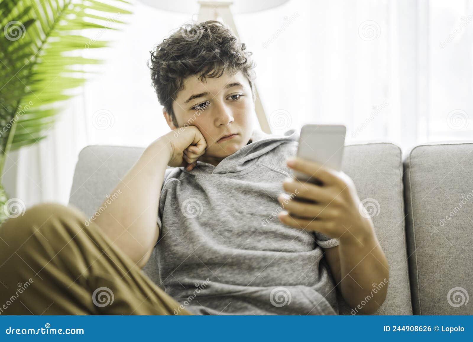 Pre-teen Sit on the Couch Using Smartphone and Look Sad and Boring ...