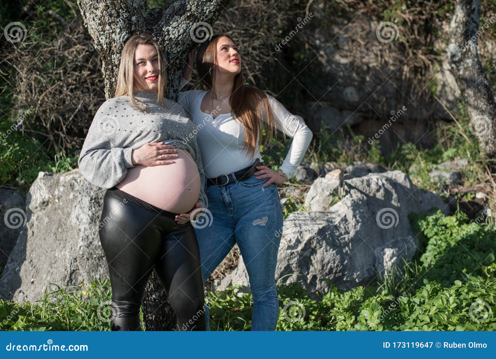 Pregnant Girl Showing Belly Next To Long Haired Curvy Girl Stock Image