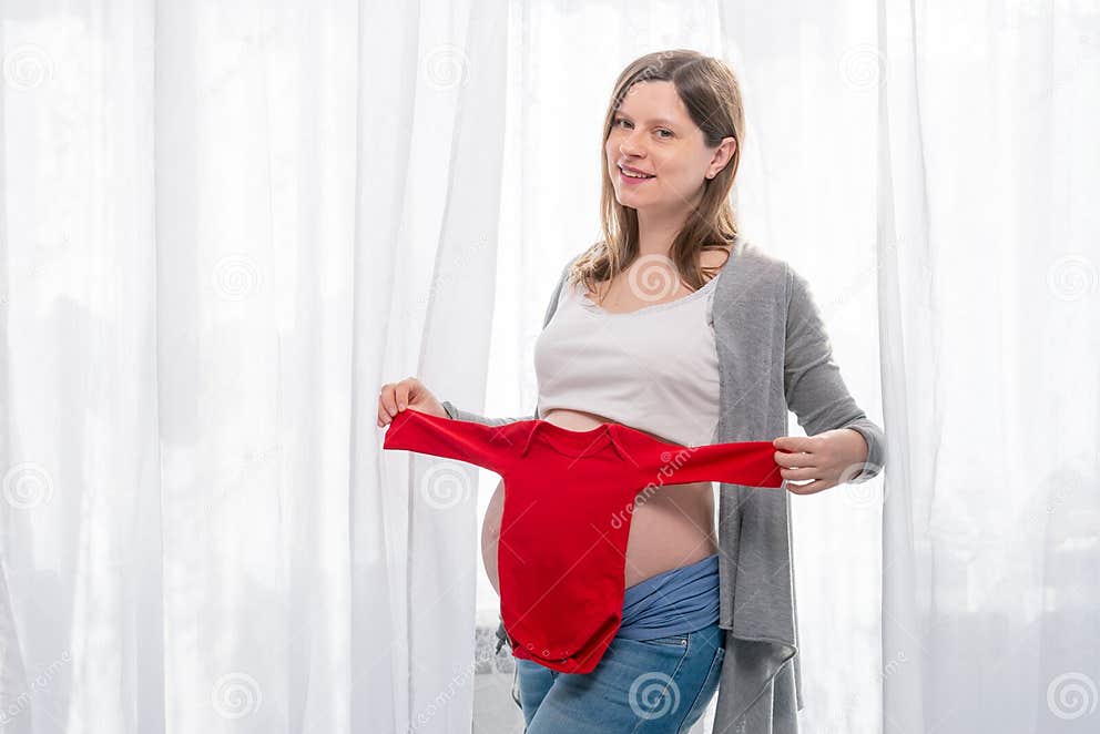 Pregnant Woman With Big Belly Trying Red Bodysuits On Her Belly
