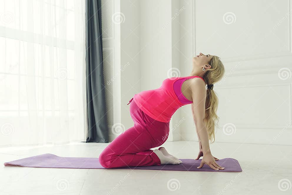 Pregnant Woman With A Tummy Does Yoga Doing A Bend Sitting On Her Knees