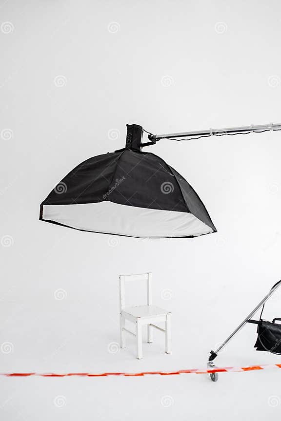 Preparation for Studio Shooting: Empty White Chair and Studio Lighting ...