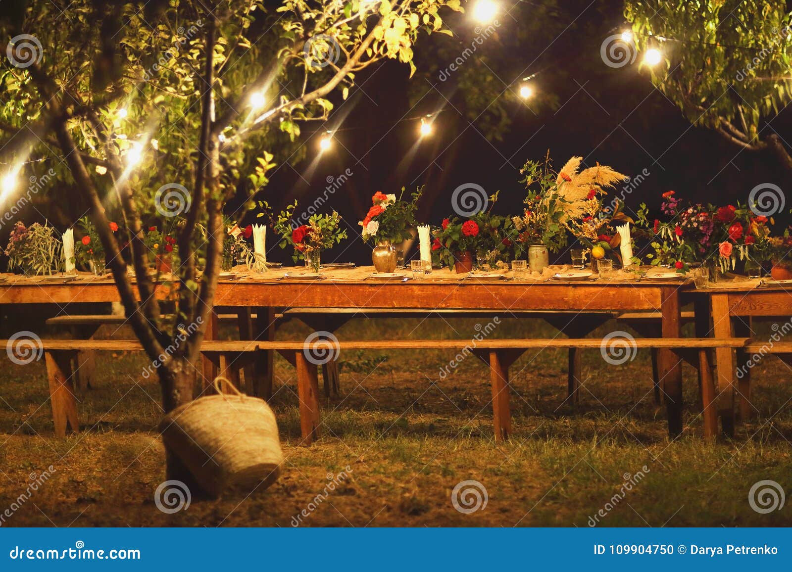 Prepared Table for a Rustic Outdoor Dinner at Night with Wineglasses ...