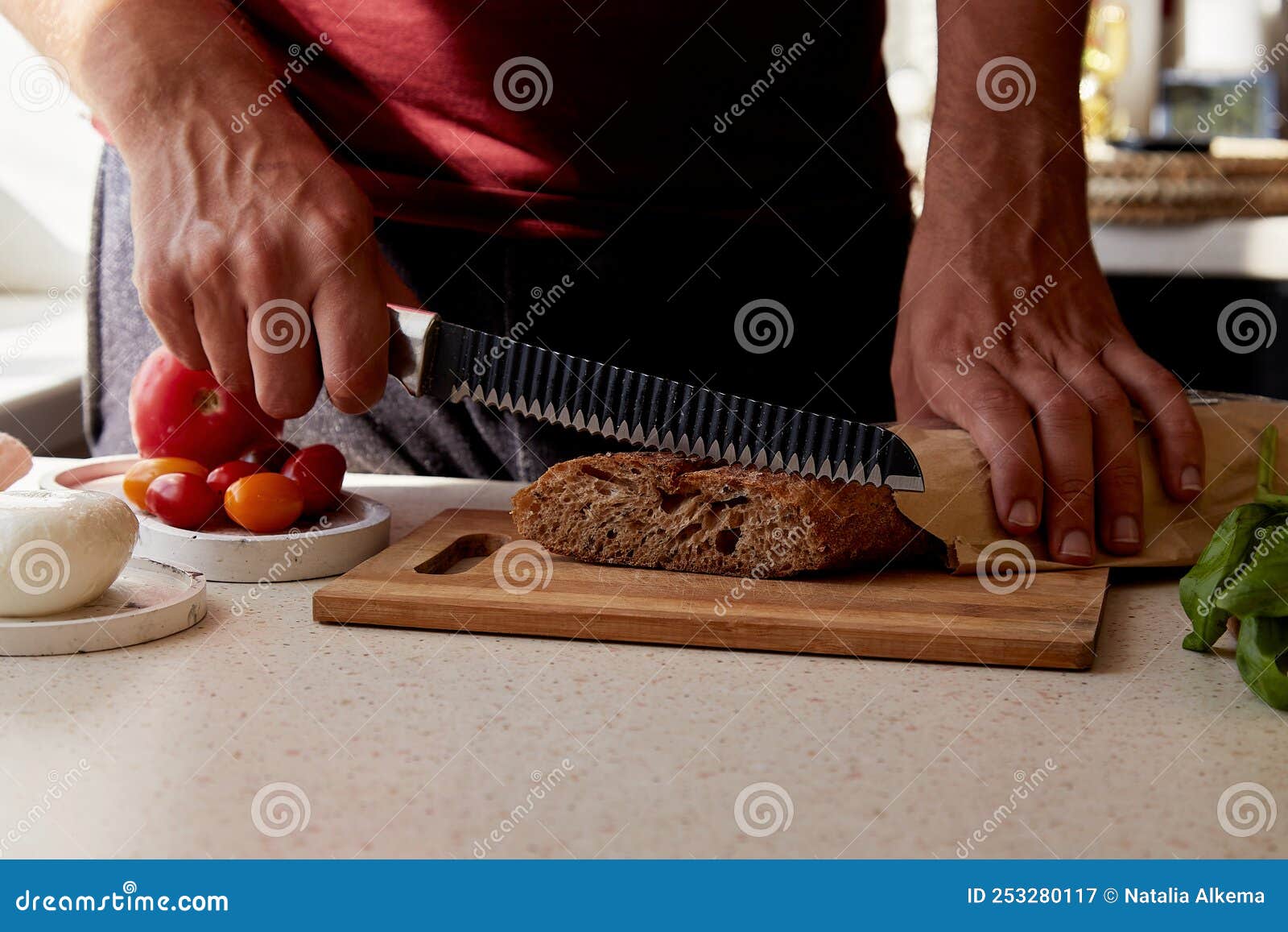 Preparing a Dinner. Man is Cutting a French Fresh Grain Baguette in the ...