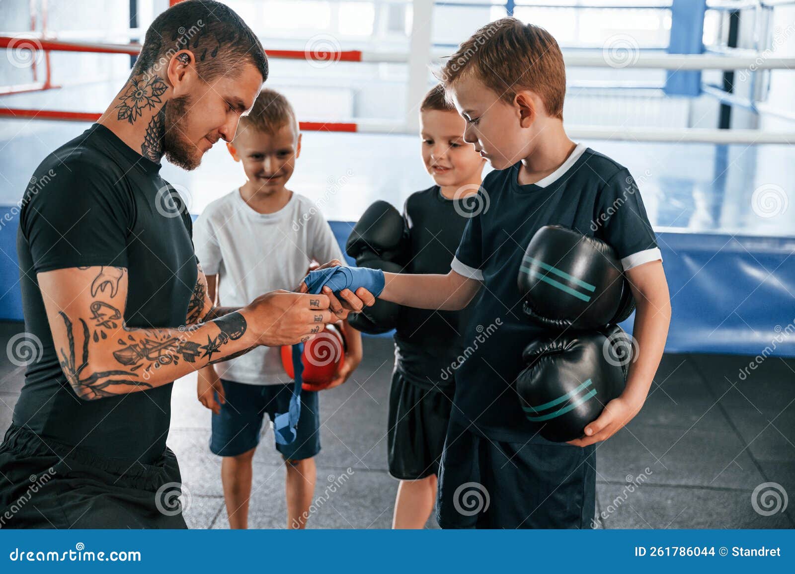 Preparing for the Sparring. Young Tattooed Coach Teaching the Kids ...