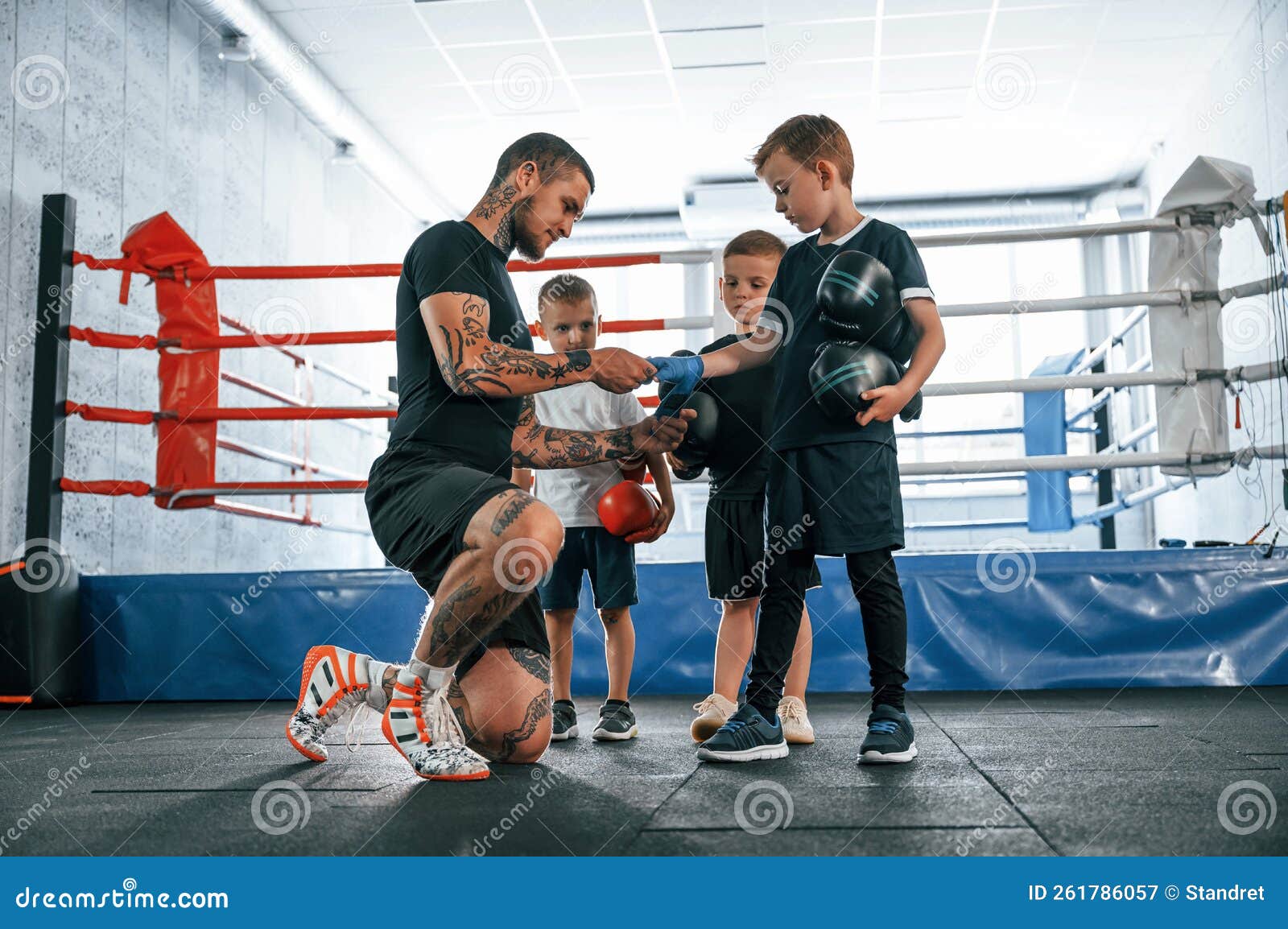 Preparing for the Sparring. Young Tattooed Coach Teaching the Kids ...