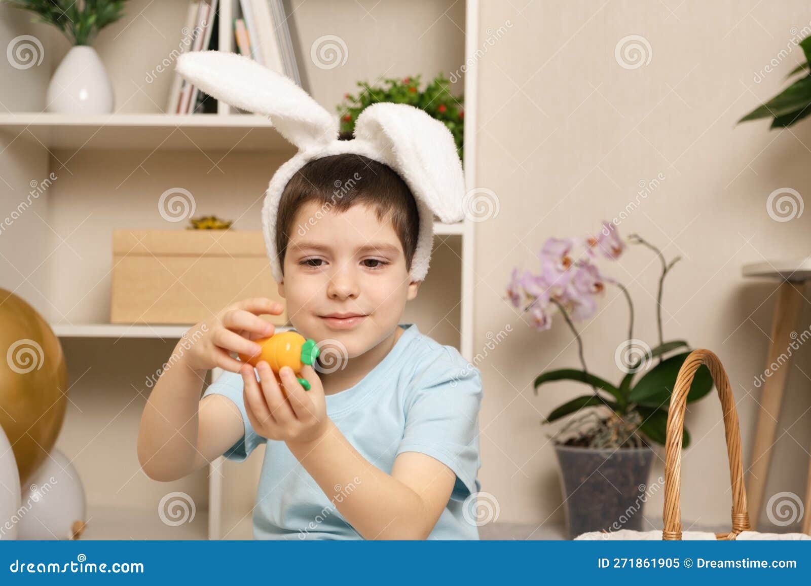 A Preschool Easter Boy Plays with Carrots, Rabbit Ears on His Head ...
