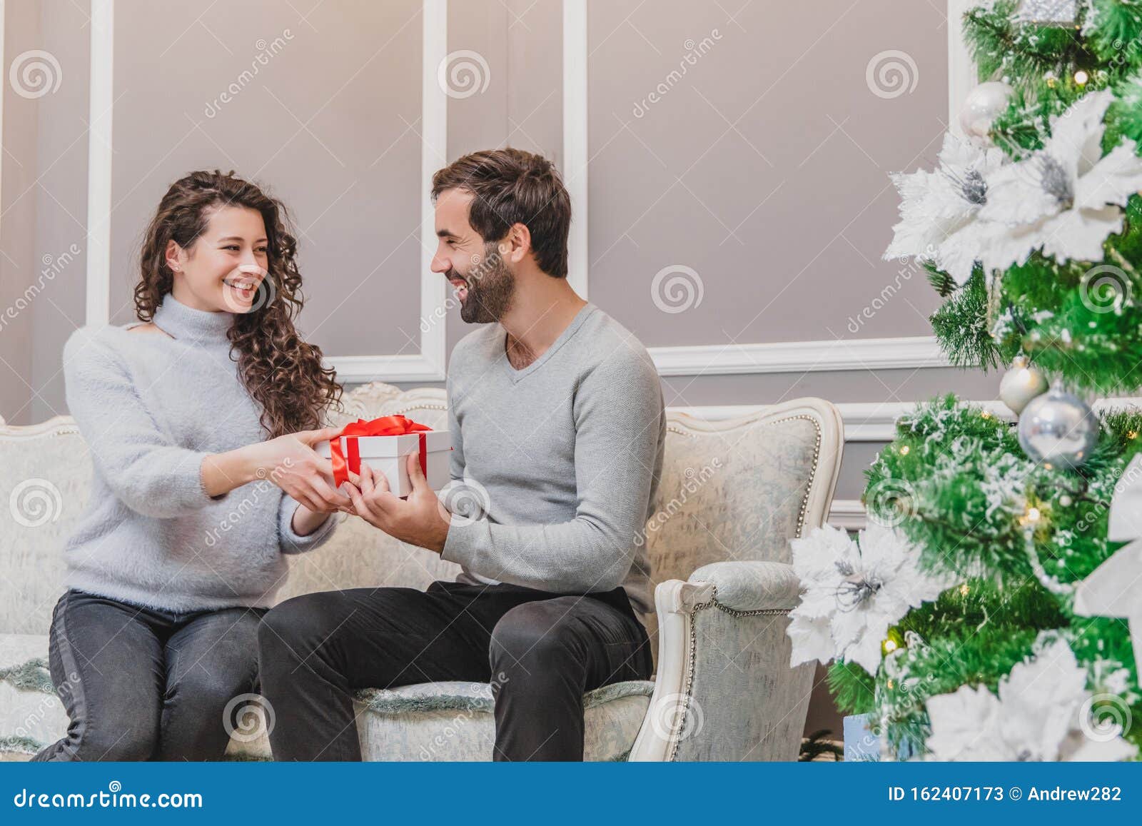 Image of Affectionate Girl Giving Present Her Boyfriend while Sitting ...