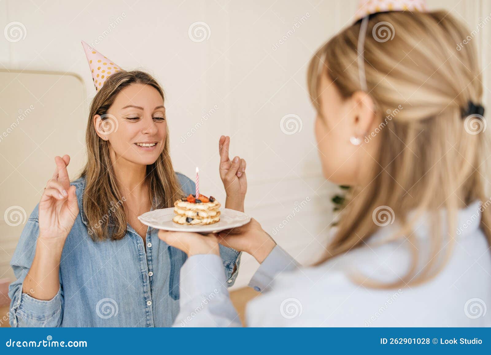 Pretty Adult Caucasian Woman Blowing Out Candle On Cake Crossing Her