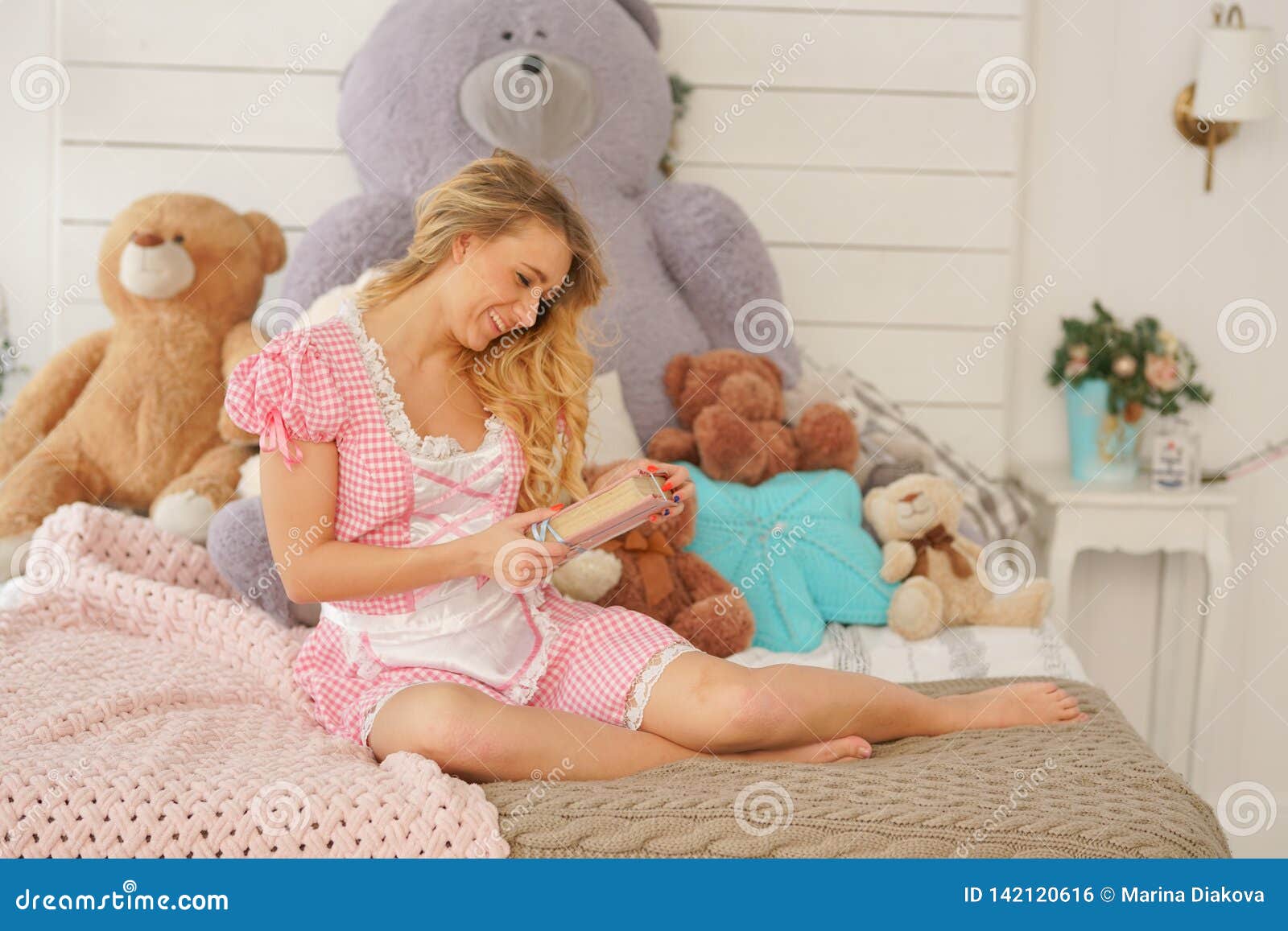 Pretty Adult Girl With Her Secret Diary In Her White Bedroom With Many Plush Teddy Bears Stock